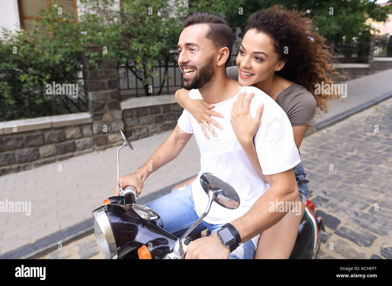 Young couple riding motor scooter in city Stock Photo - Alamy
