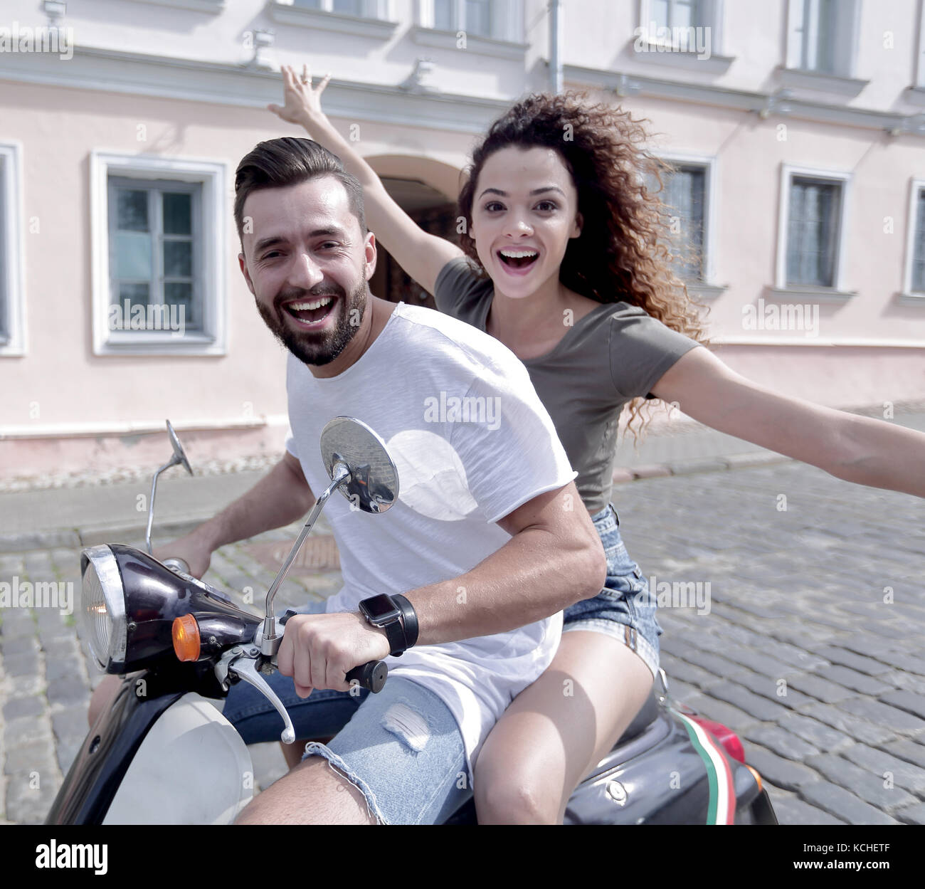 Cheerful young couple riding a scooter and having fun Stock Photo - Alamy