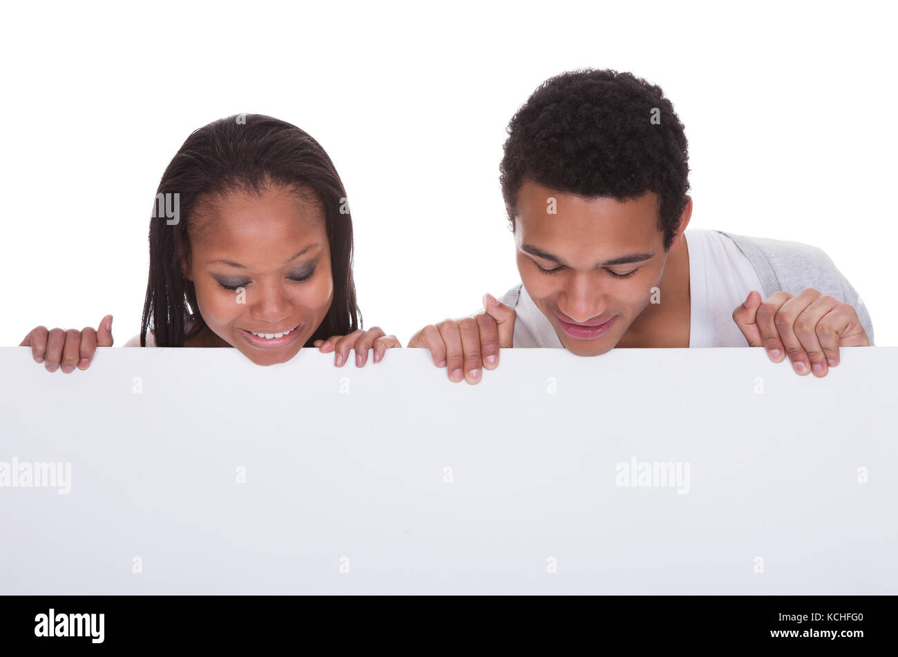 Young Couple Holding Placard Over White Background Stock Photo - Alamy Young Couple Holding Placard Over White Background Stock Photo - Alamy