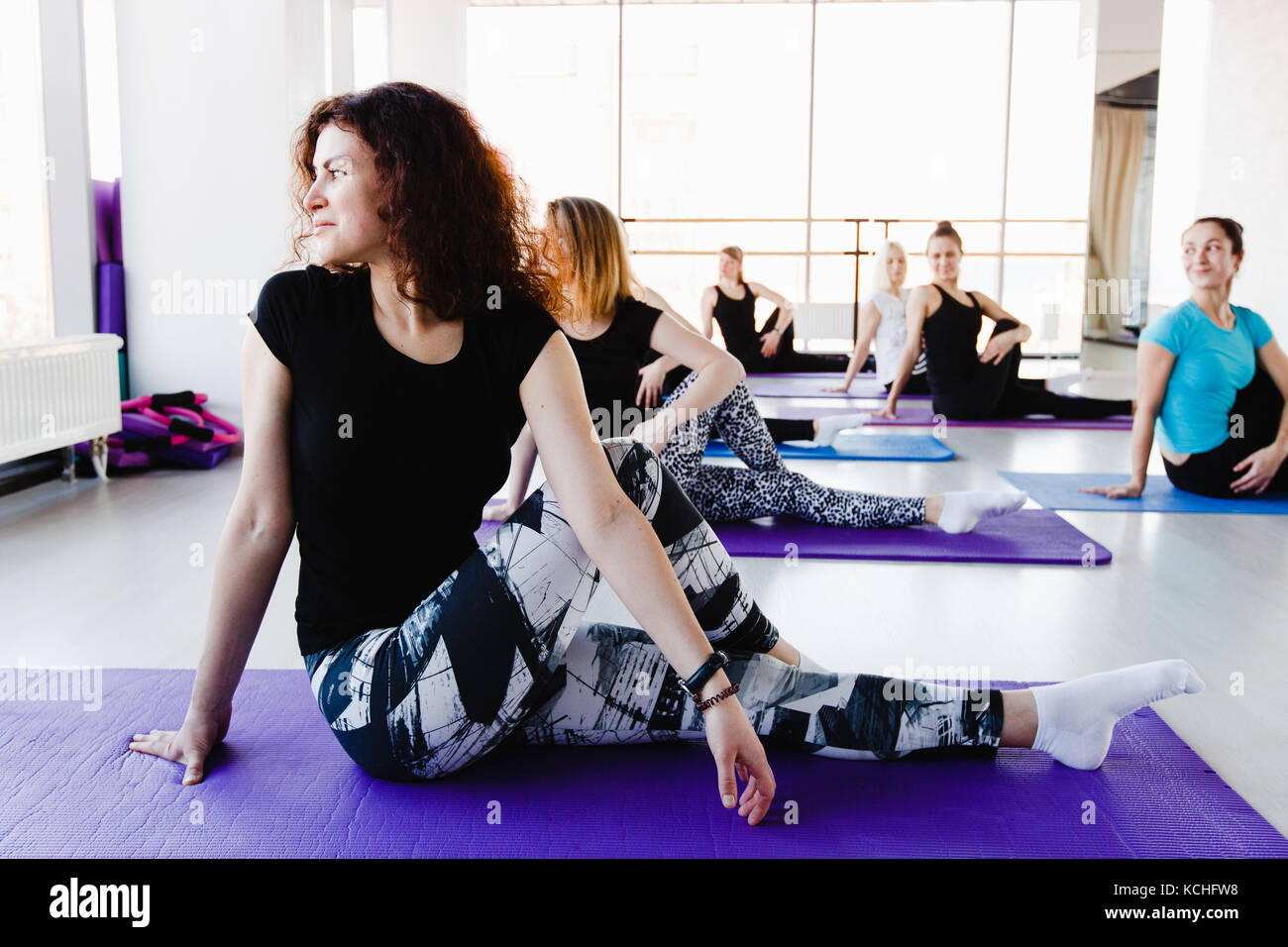 Young women doing stretching exercises in the aerobics class on the ...