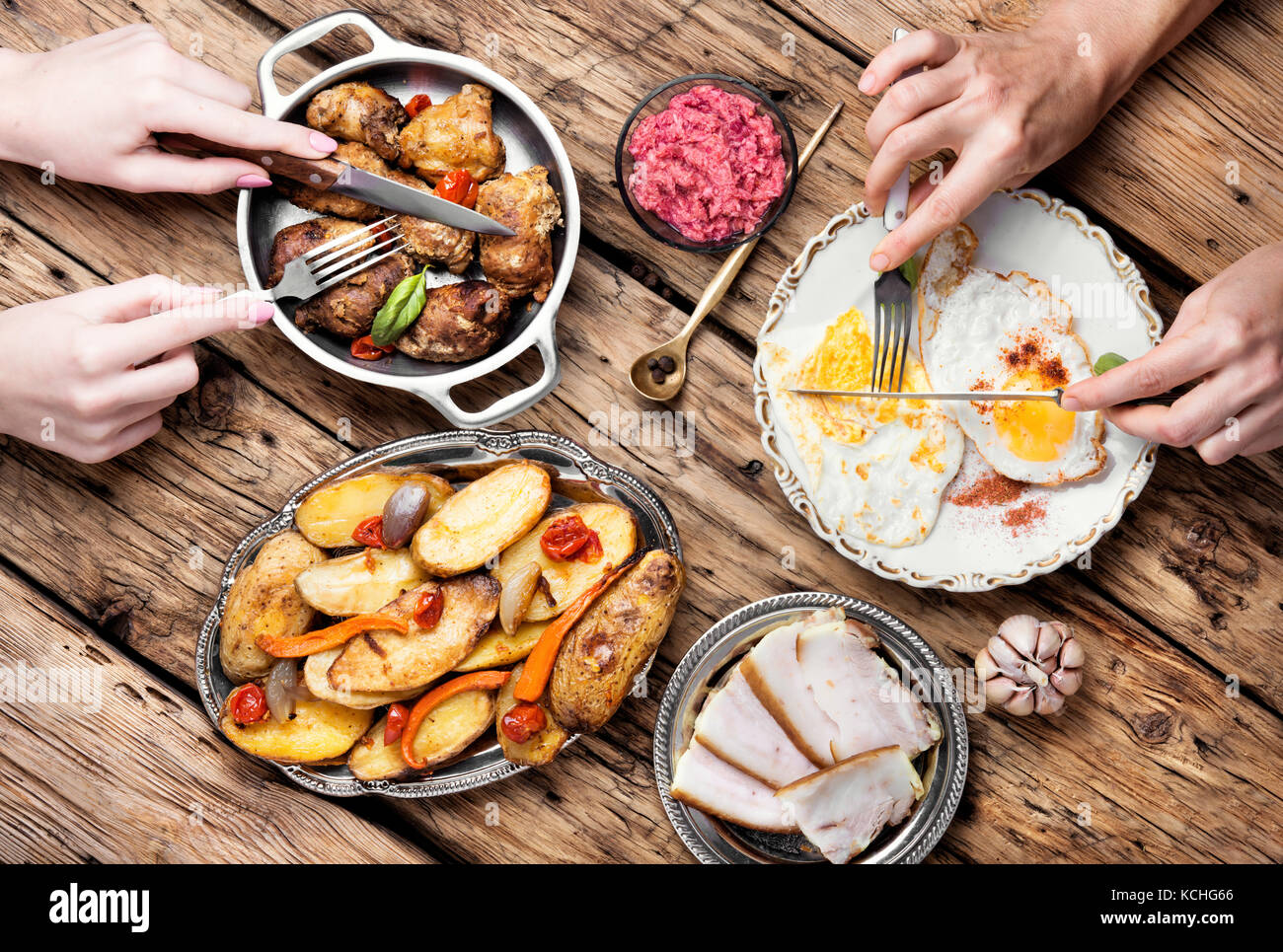 Food background. Two people at a dinner table with meat, potatoes and ...