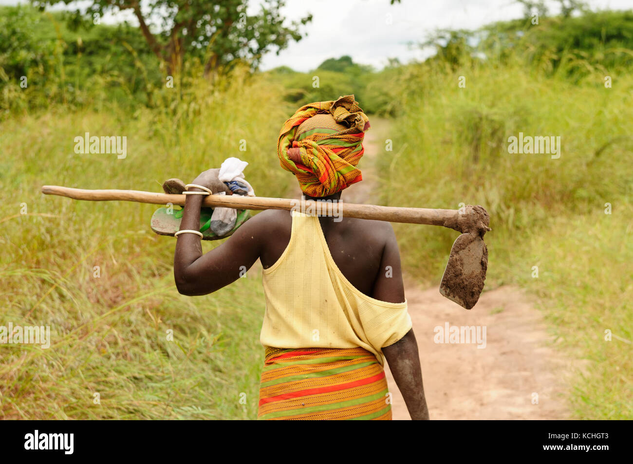 African woman going to work with the hoe in field Stock Photo - Alamy