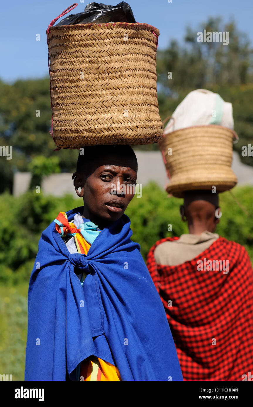 ARUSHA, TANZANIA - MAY 19: African women with woven basket on her head ...