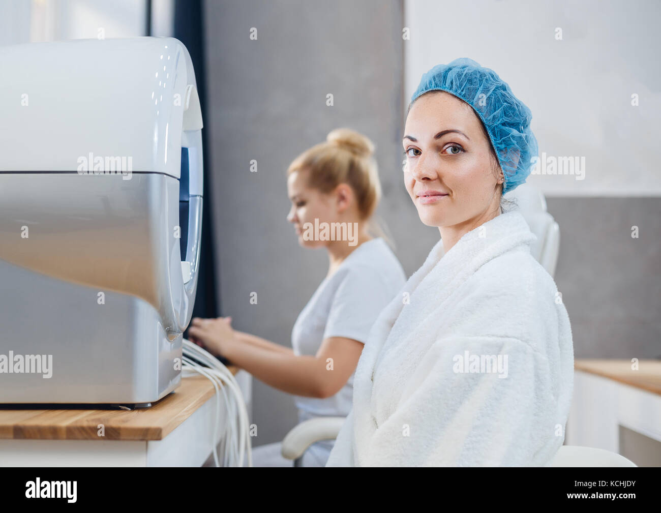Happy smiling female patient with doctor in the background Stock Photo ...