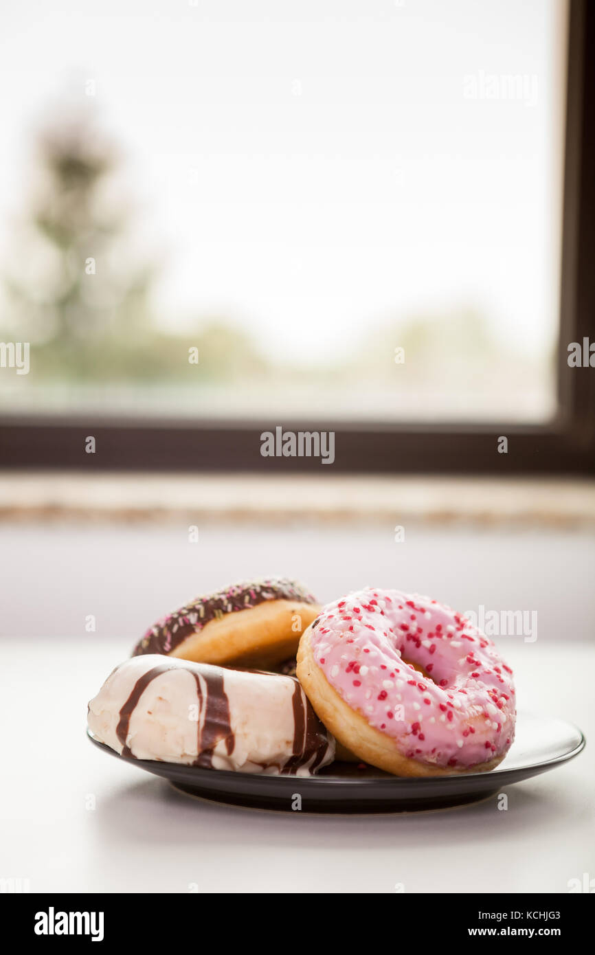 Plate with donuts next to window Stock Photo - Alamy