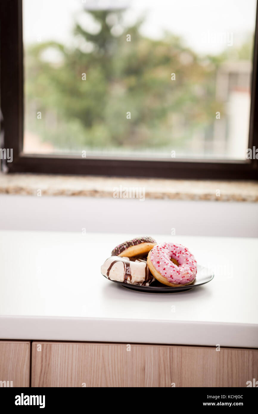 Plate with donuts next to window Stock Photo - Alamy