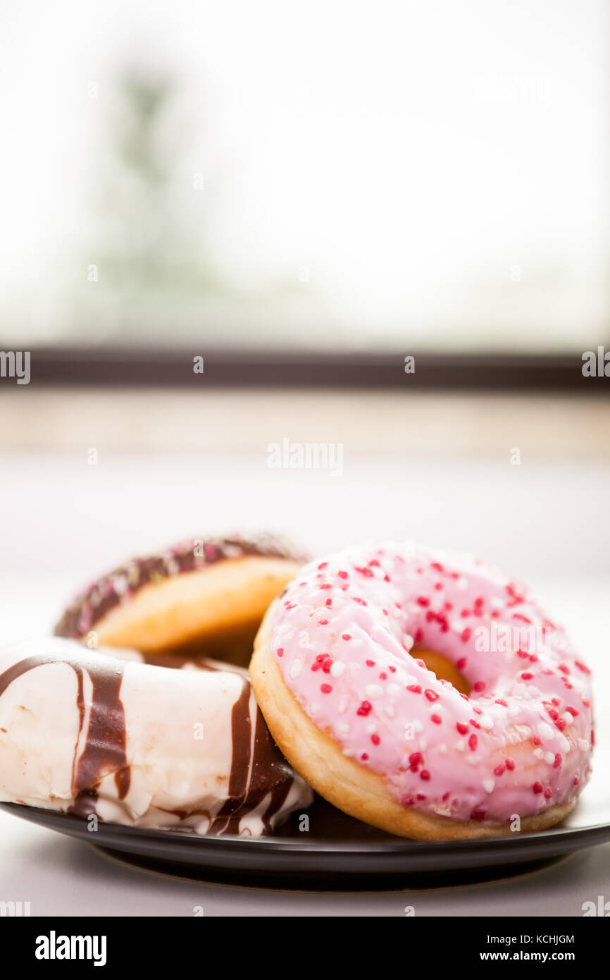 Plate with donuts next to window Stock Photo - Alamy