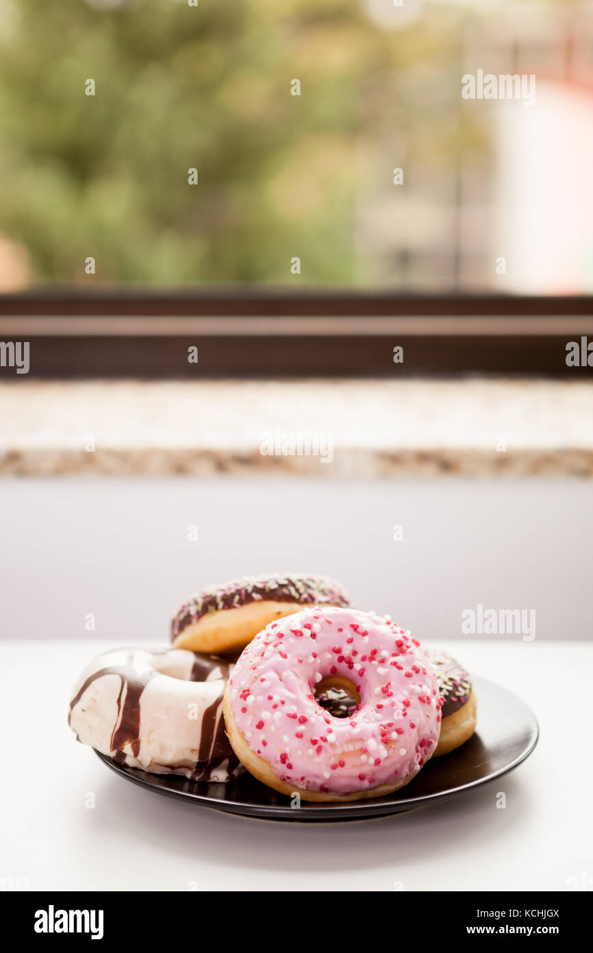 Plate with donuts next to window Stock Photo - Alamy