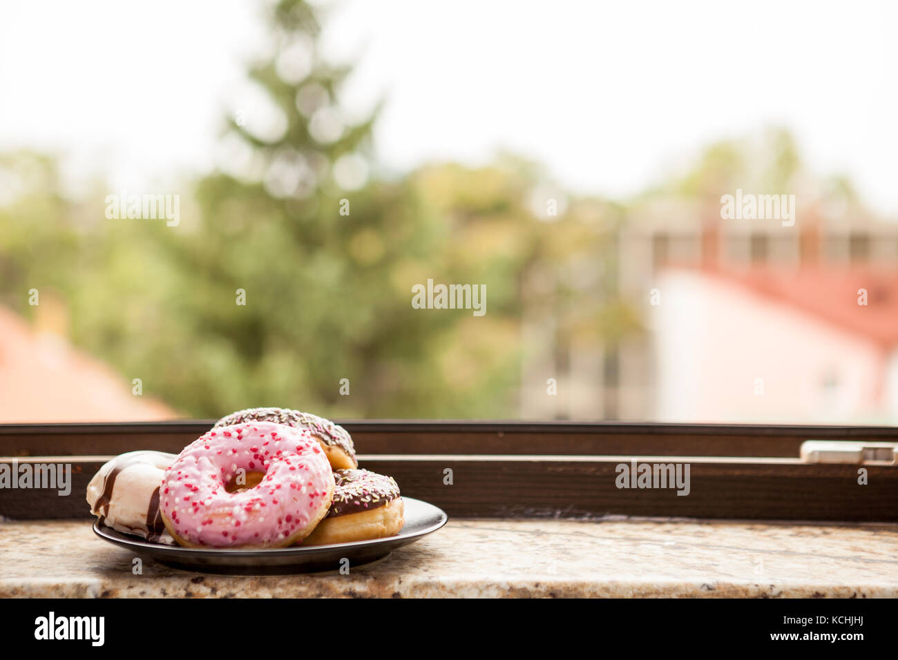 Plate with donuts next to window Stock Photo - Alamy
