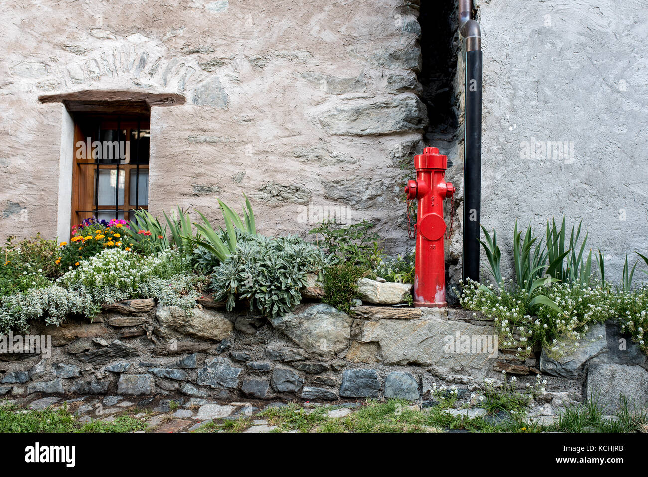 fire hydrant near a brick wall, alpine little town scene Stock Photo ...