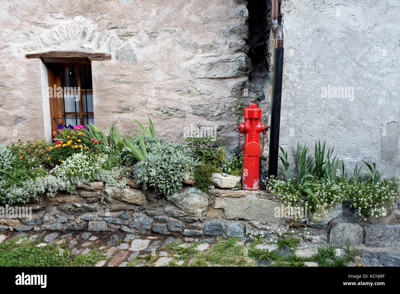 fire hydrant near a brick wall, alpine little town scene Stock Photo ...