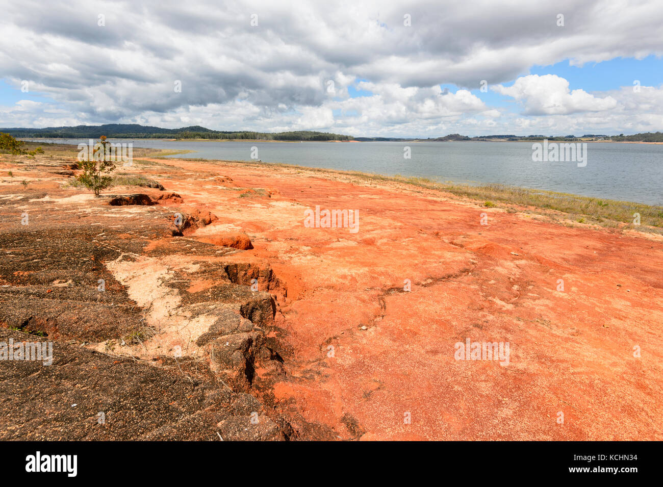 Low water level in the Tinaroo Falls Dam uncovers red rocks embankment ...