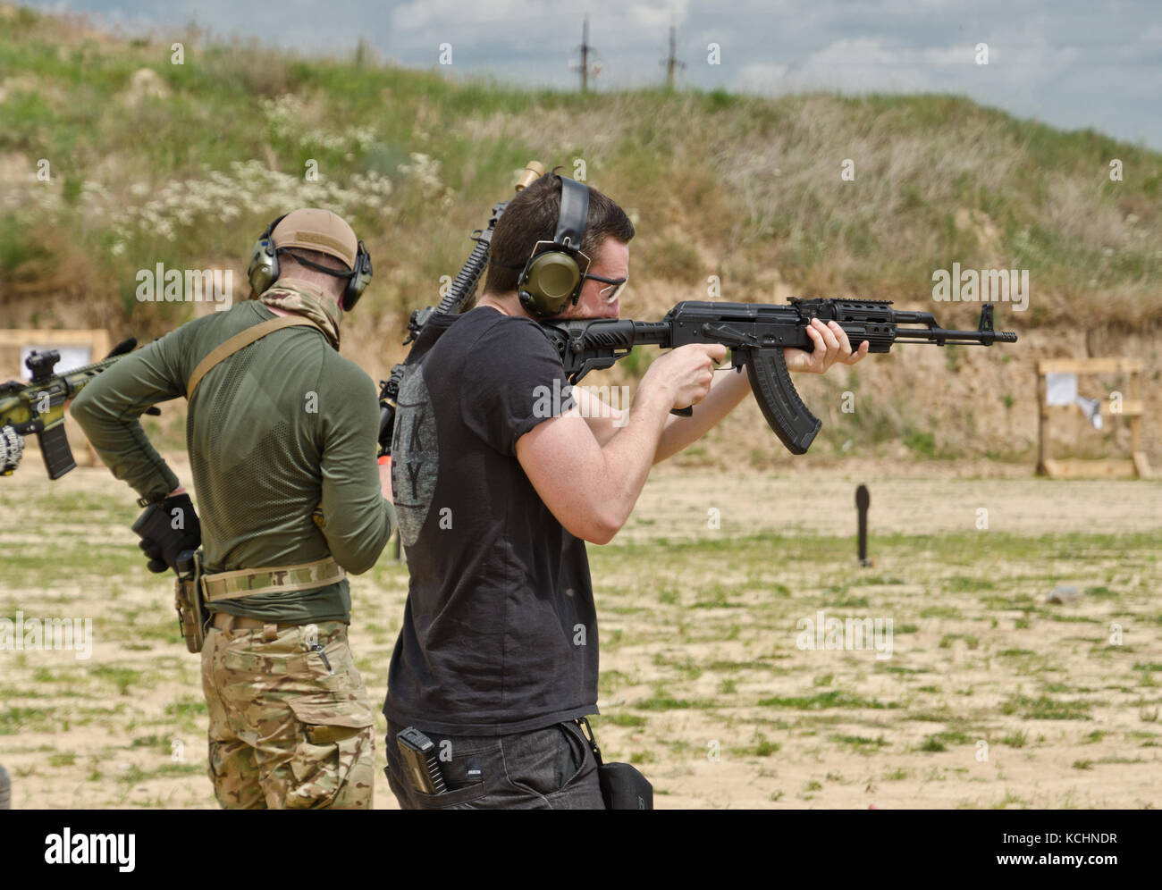 Men shooting outdoors Stock Photo - Alamy
