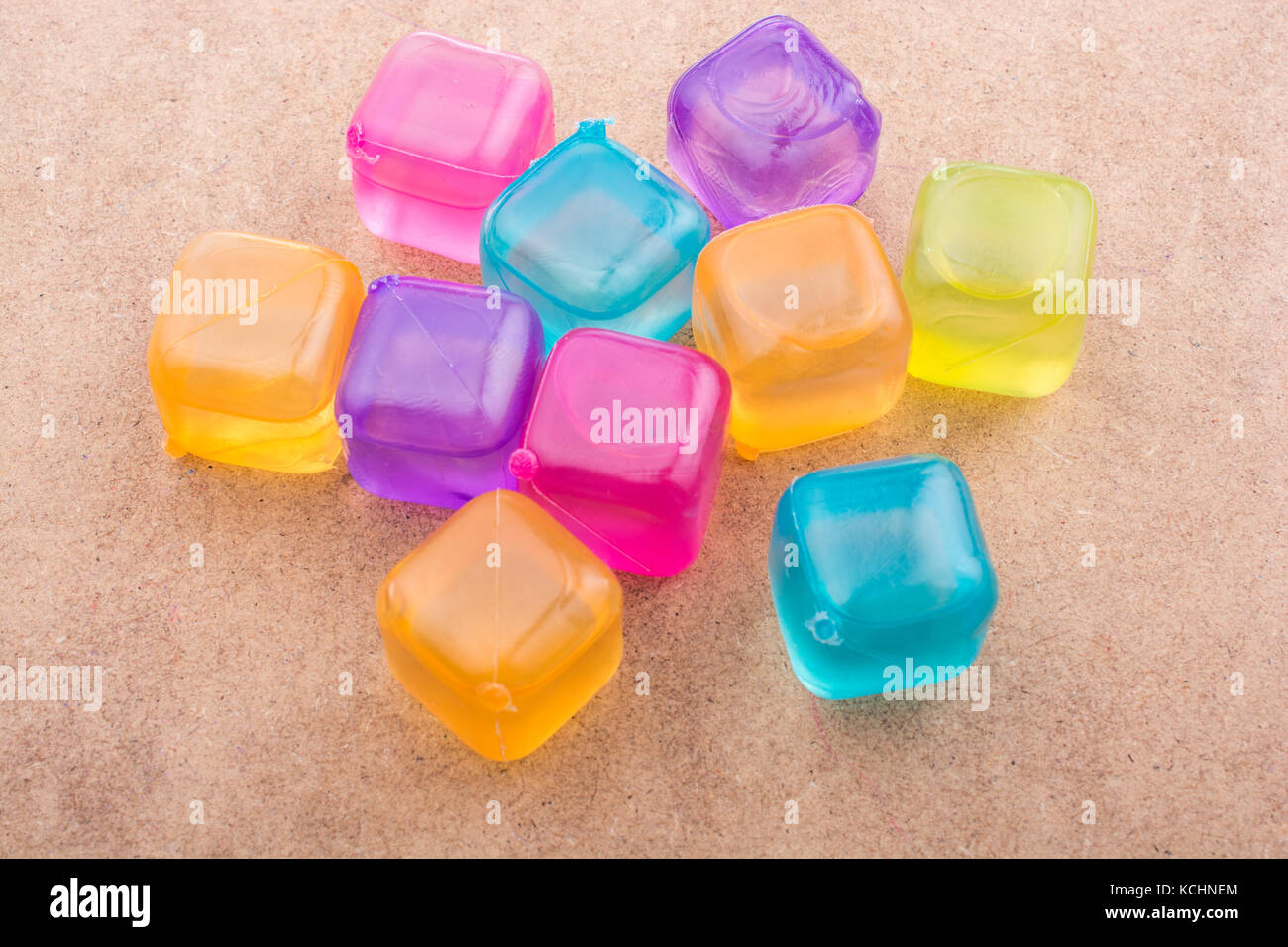 Fake colorful ice cubes on a brown background Stock Photo - Alamy