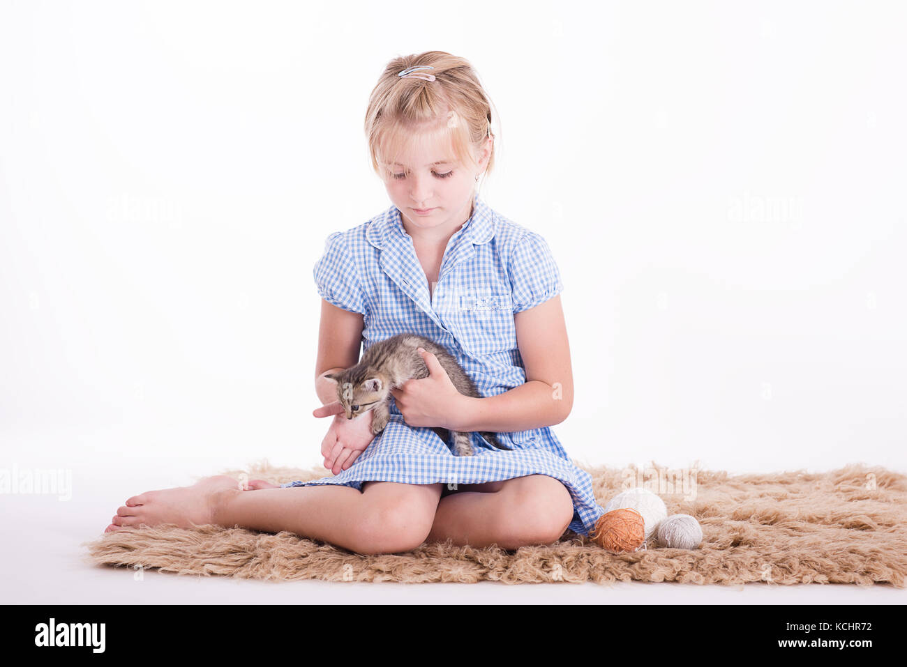 Girl playing with a kitten in studio on a white background Stock Photo ...