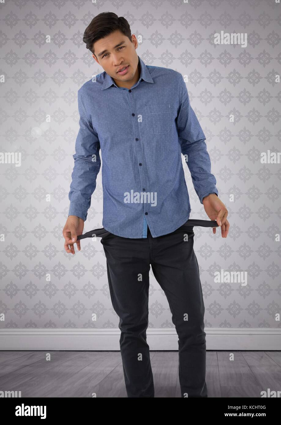 Digital composite of Businessman holding empty broke pockets in room ...