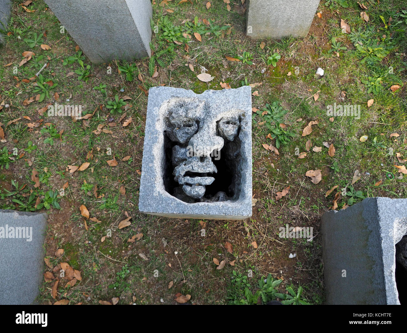 Sculpted blocks revealing faces within blank sides at the monument to ...