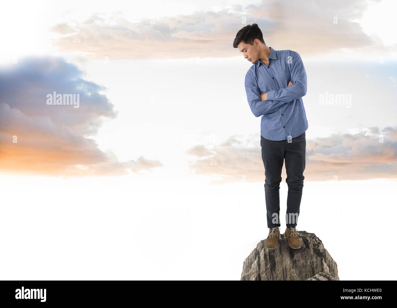 Digital composite of Businessman standing on rock looking down below ...