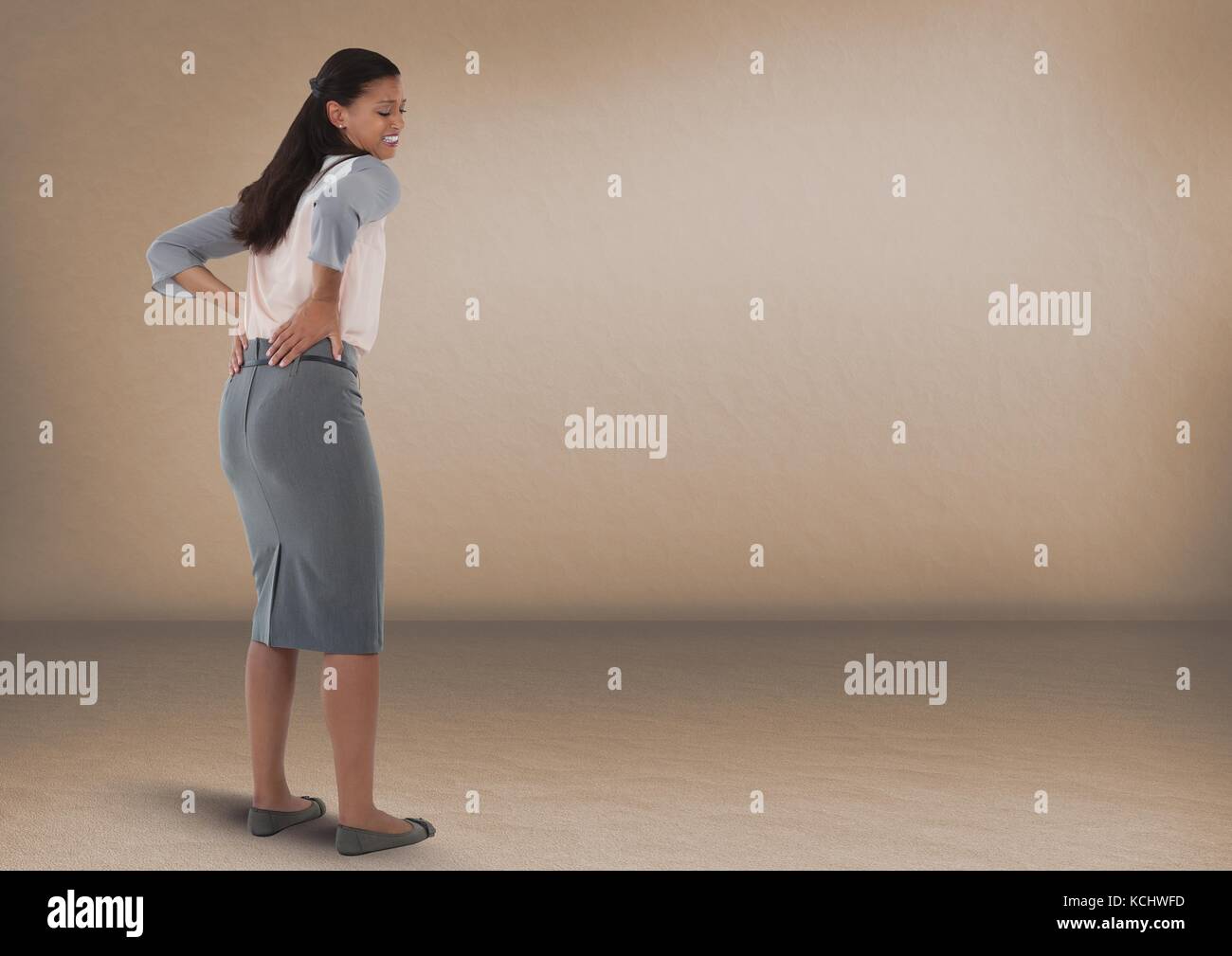 Digital composite of Businesswoman with sore back in room Stock Photo ...