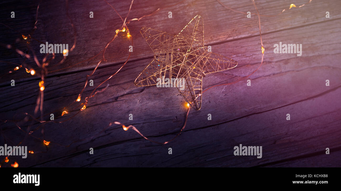 Illuminated rice lights with star on wooden plank during Christmas time ...