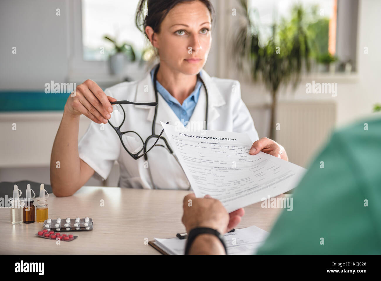 Doctor writing in patient chart hi-res stock photography and images - Alamy