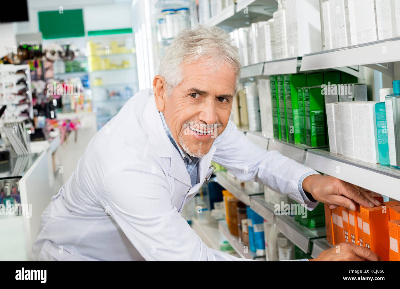 Confident Pharmacist Arranging Medicines On Shelf In Pharmacy Stock ...