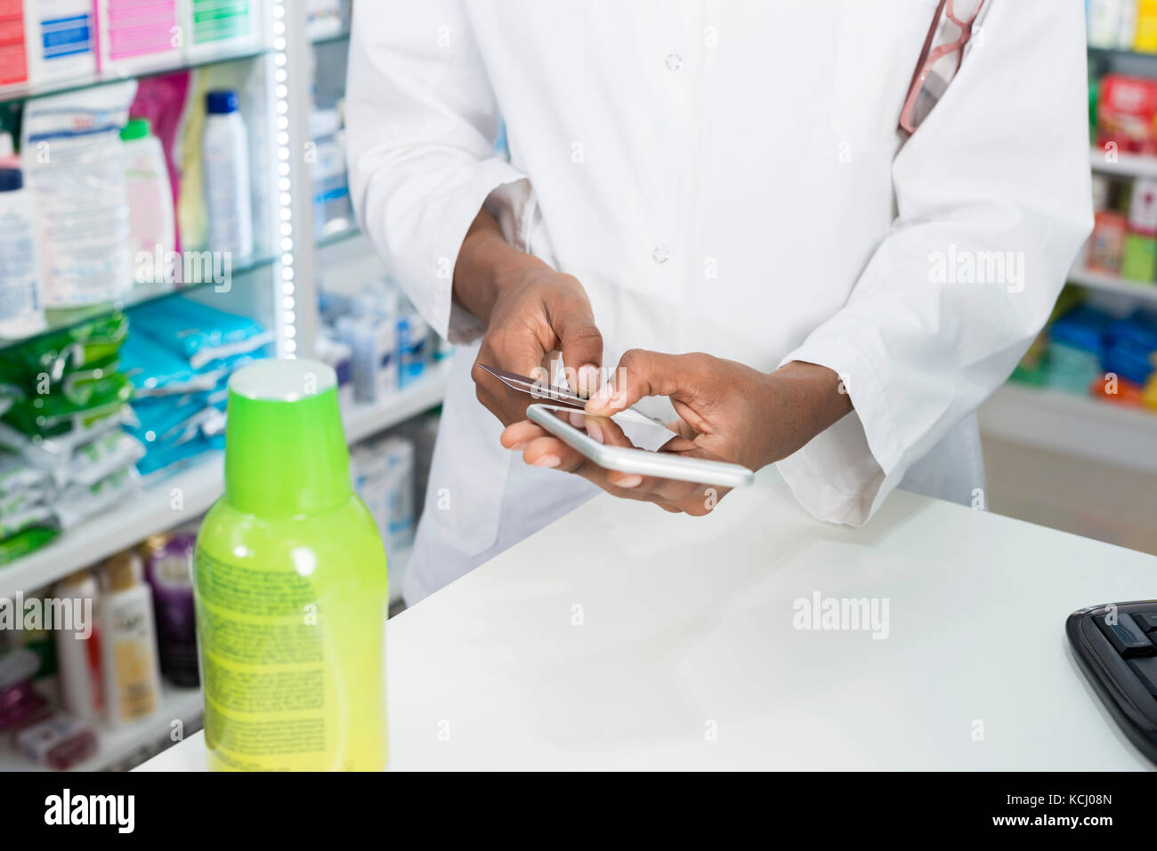 Female Pharmacist Using Smartphone Credit Card Reader At Counter Stock ...