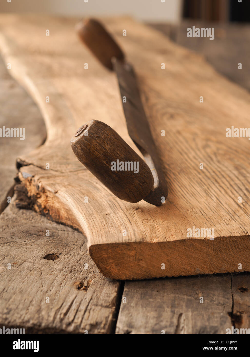 Old wood plane on a rustic oak plank, wood working or carpentry ...