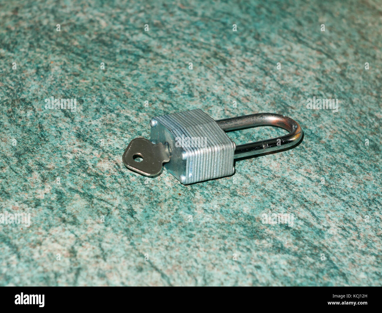metal padlock with key inside on top of counter close up isolated ...