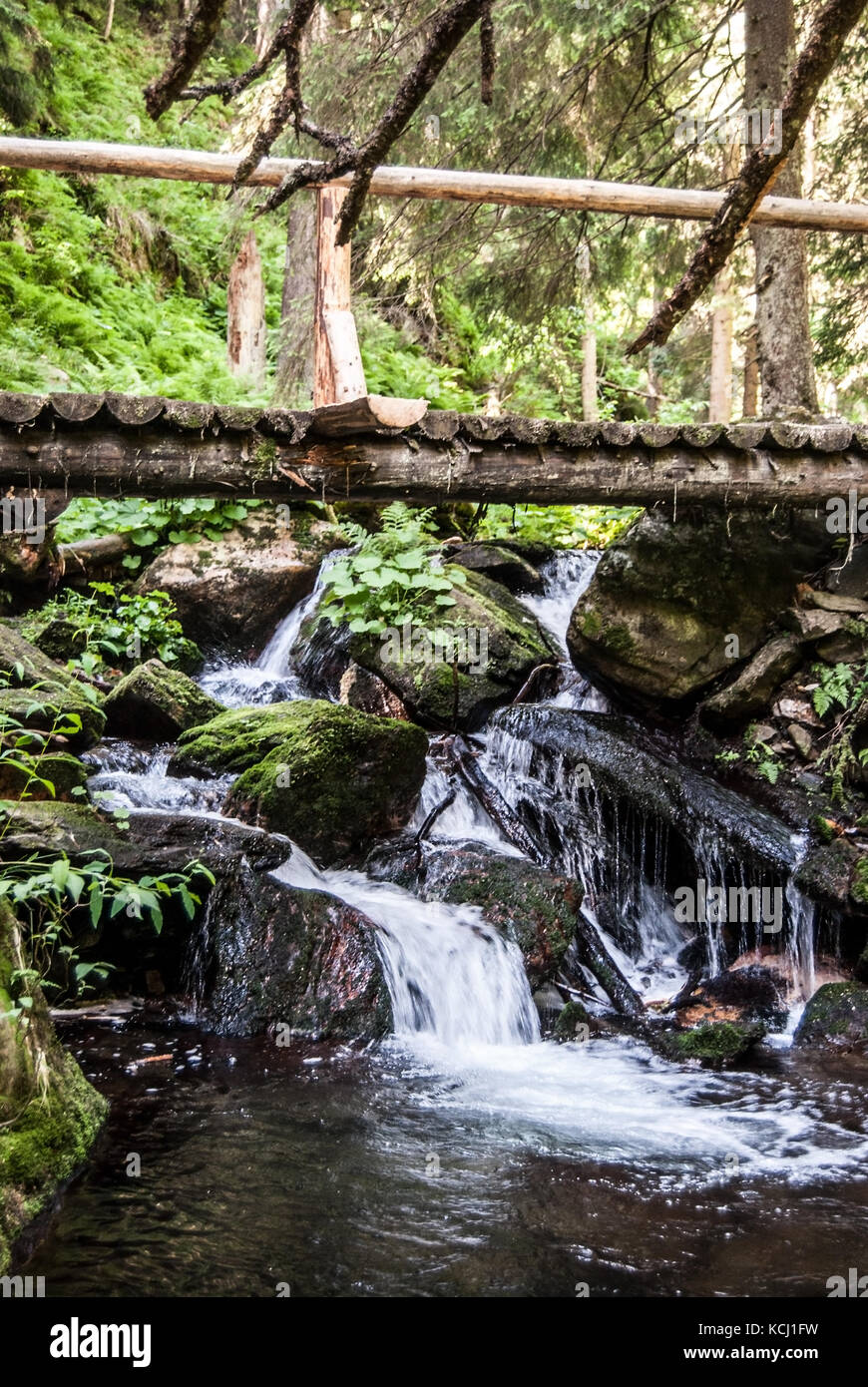 waterfall with wooden bridge above on Bila Opava river in Jeseniky ...