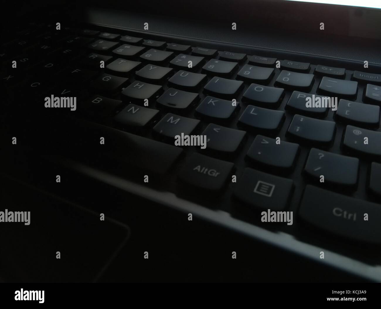 Close-up of laptop keyboard illuminated by the laptop's own screen ...
