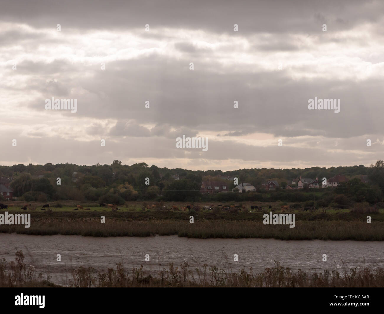 overcast dramatic grey storm clouds above river through country land ...