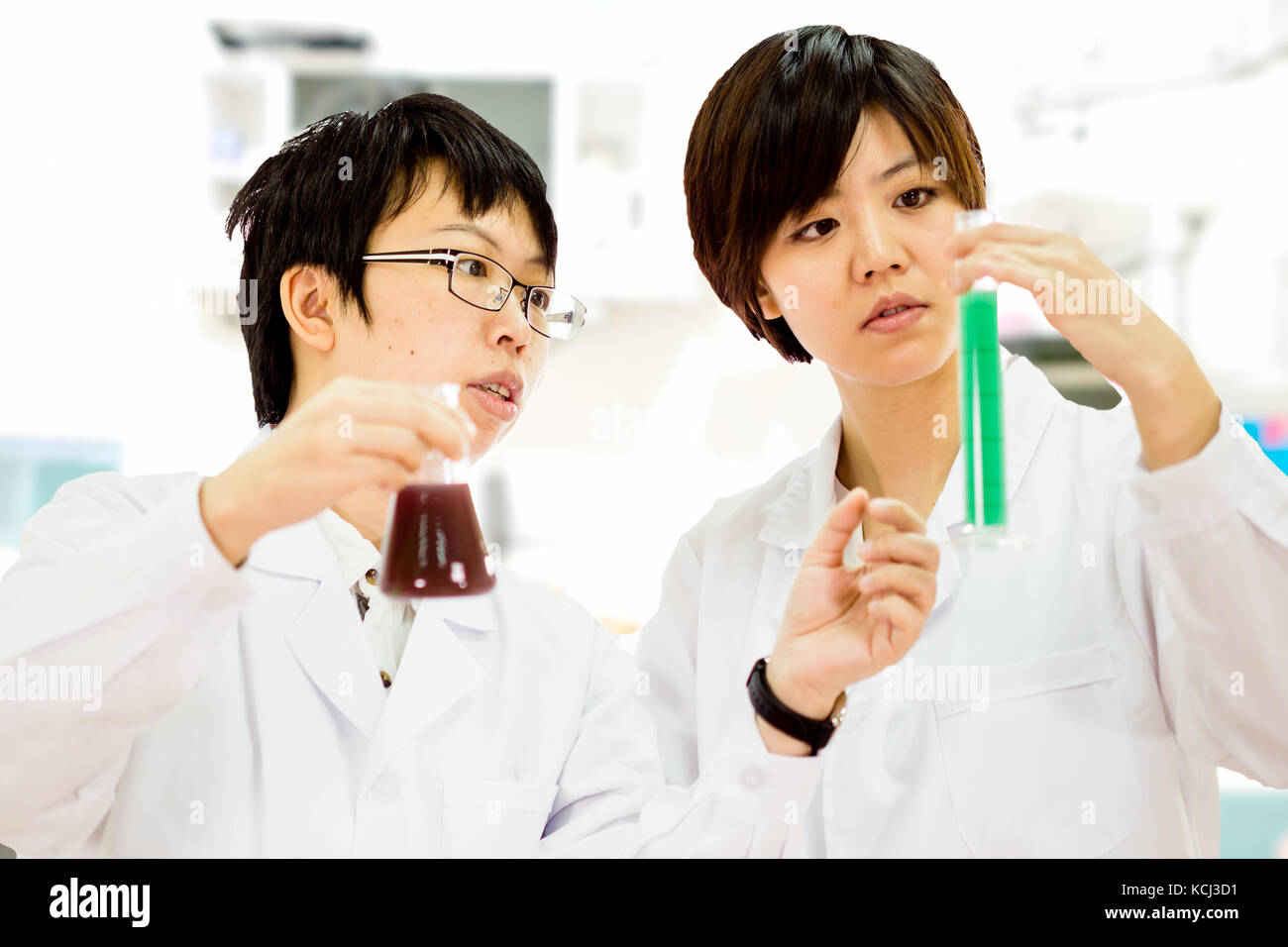 Female Chinese scientists in a laboratory inspecting chemicals in tube ...