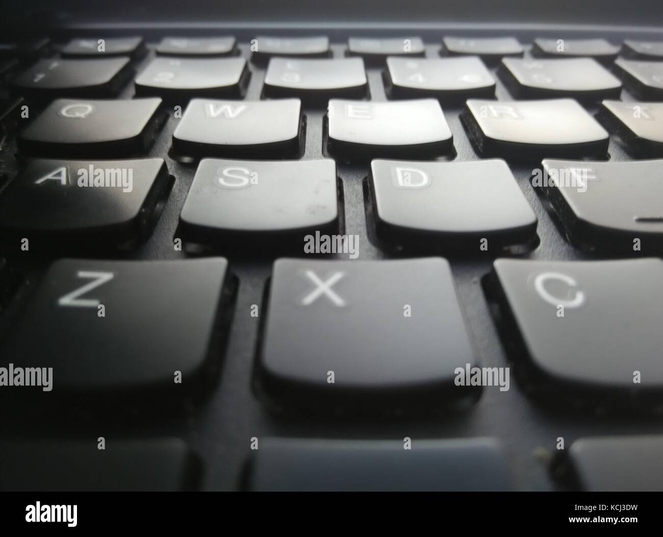Close-up of laptop keyboard illuminated by the laptop's own screen ...