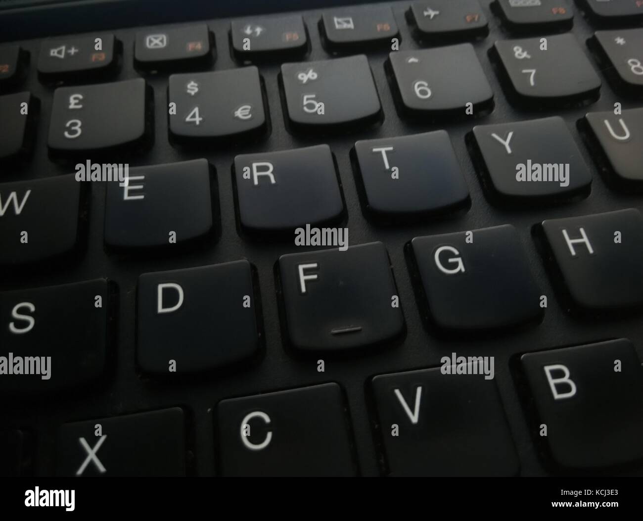Close-up of laptop keyboard illuminated by the laptop's own screen ...