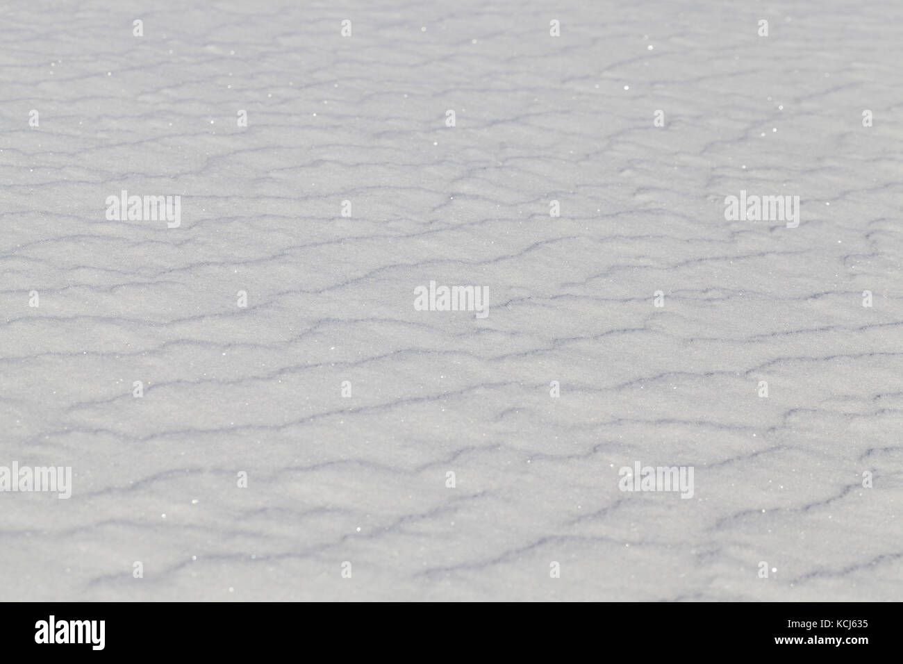 wavy snowy surface. On pure snow there are dark shadows from unevenness ...