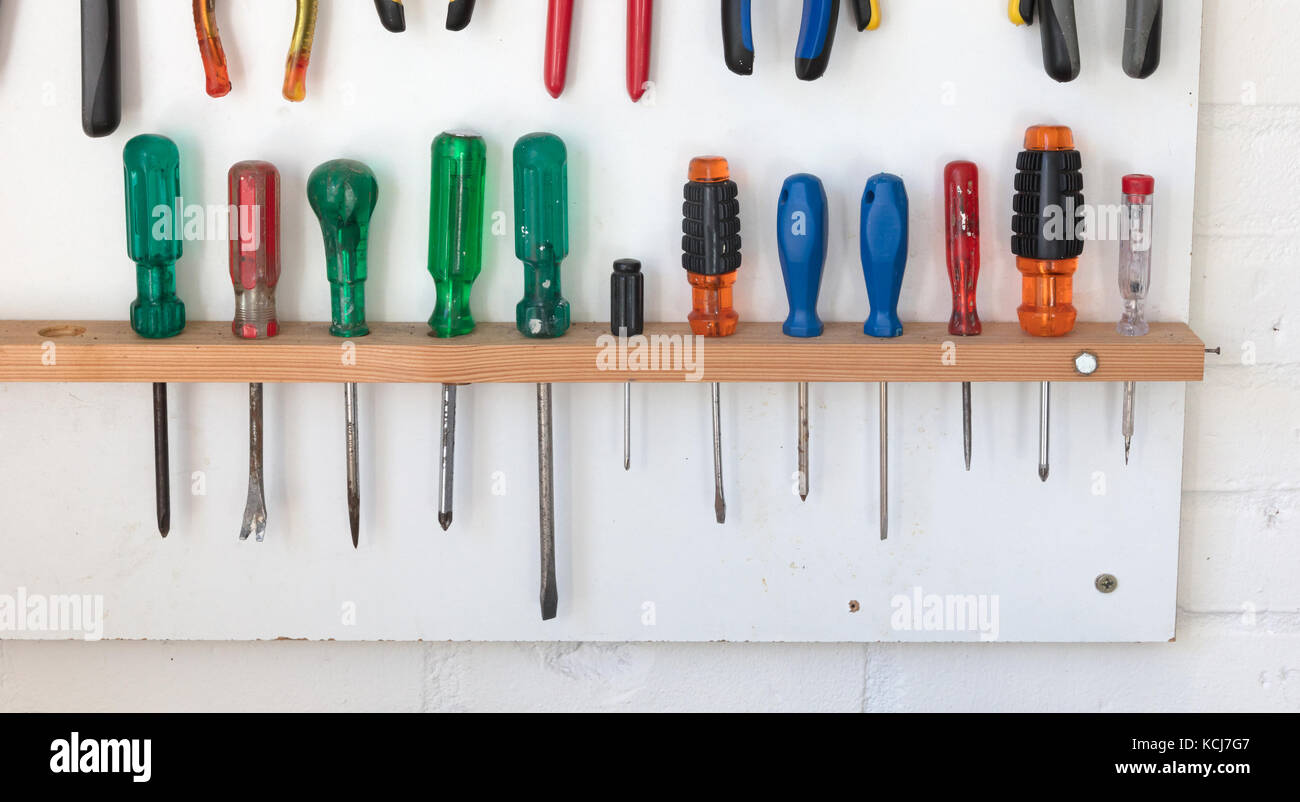 Assorted tools on a white tool board - Simple setting Stock Photo - Alamy