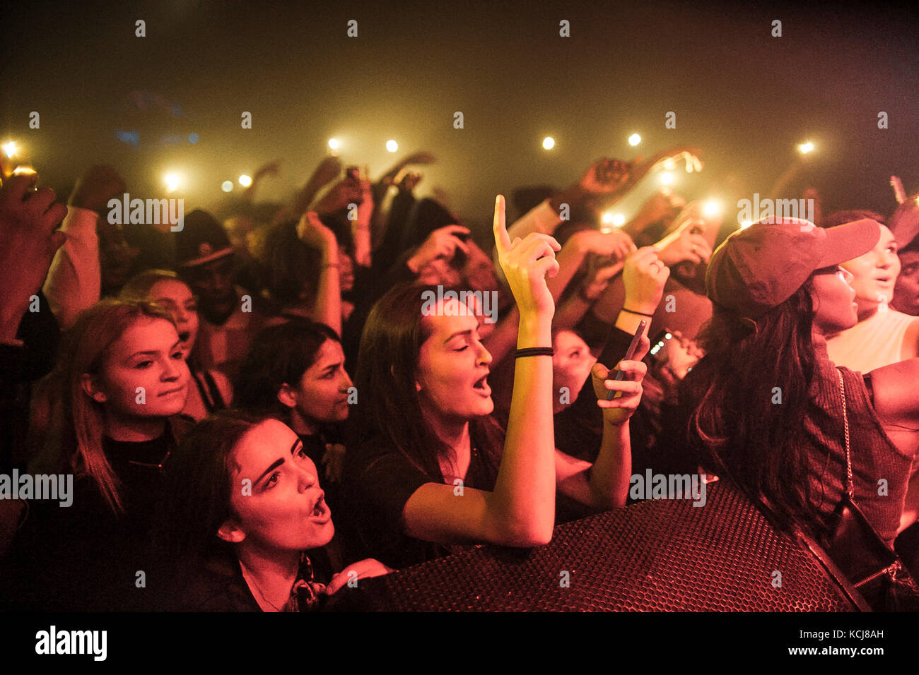 Energetic music fans and concert goers attend a live concert with the ...