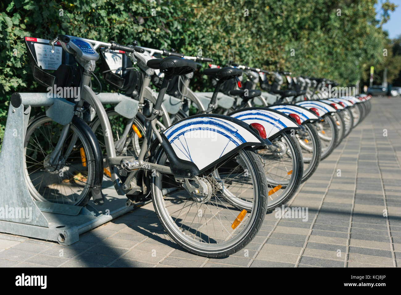 Set of vacant public bikes orderly parking locked on rack available for ...