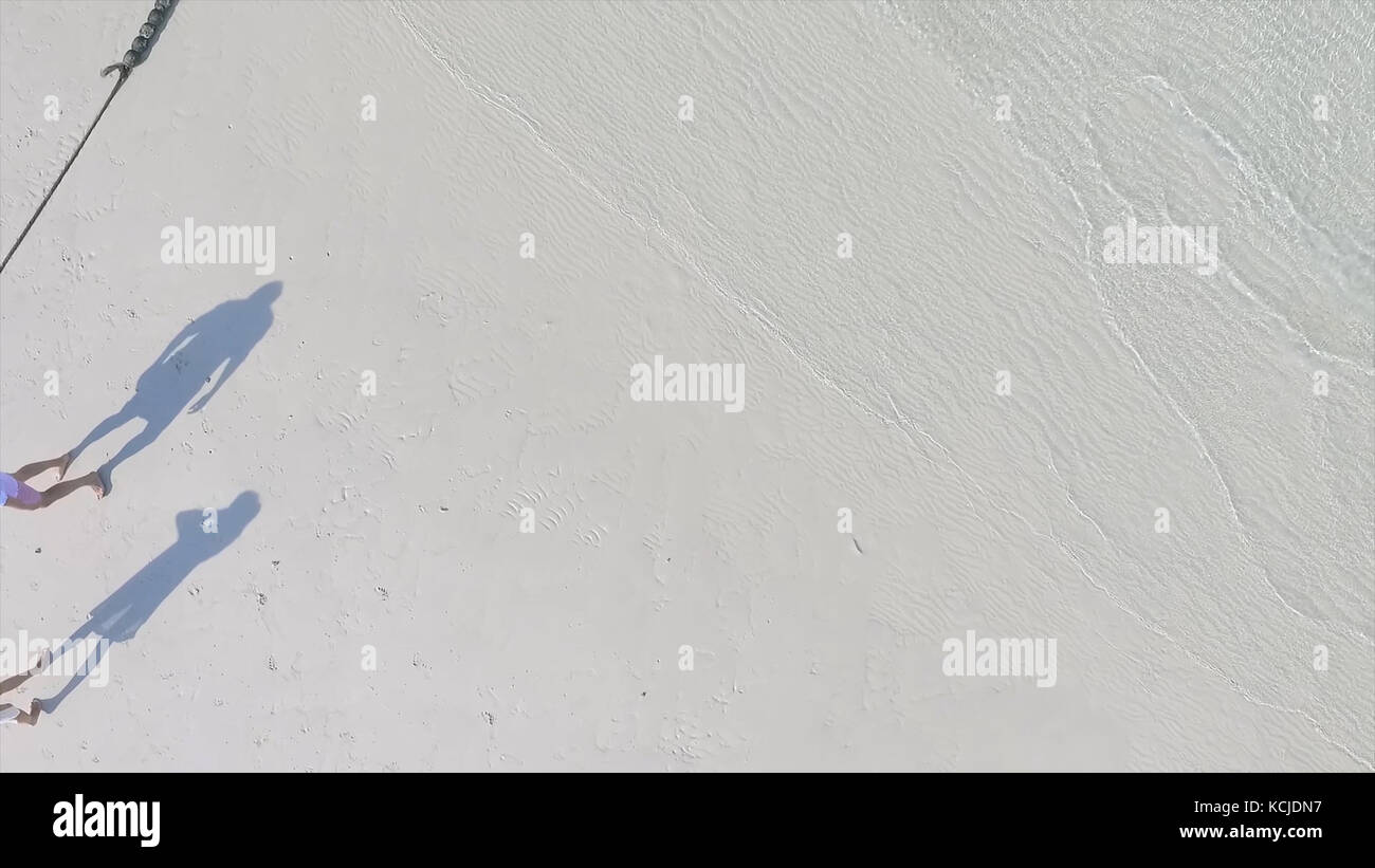 Shadow of couple on beach. Long shadow of young couple on beach sand ...