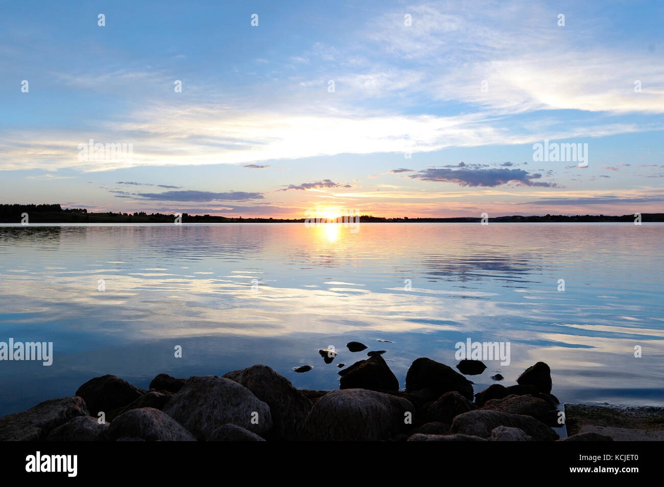 The sunset reflecting off of Lake Tschida in North Dakota Stock Photo ...