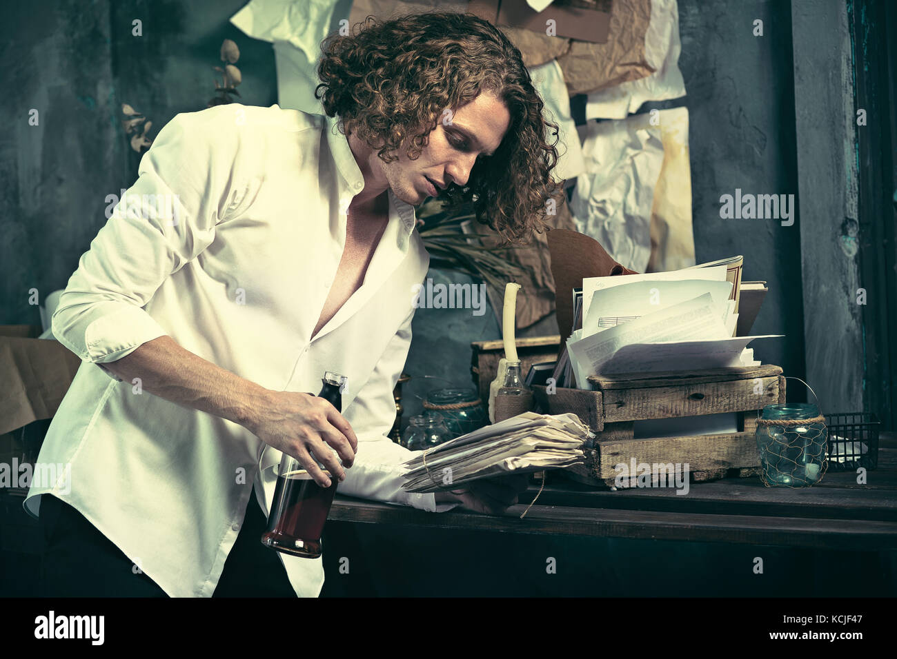 Writer at work. Handsome young writer standing near the table and ...
