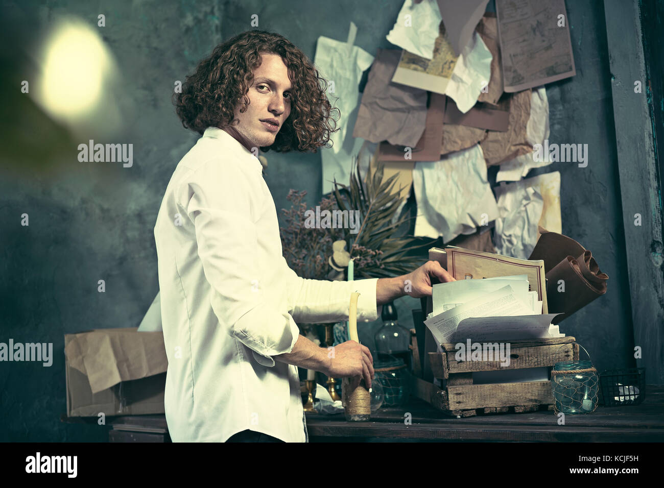 Writer at work. Handsome young writer standing near the table and ...