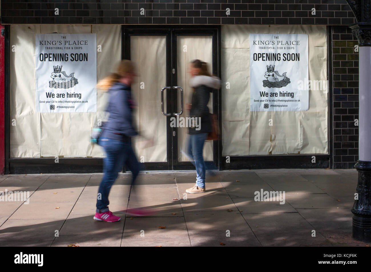 Out of focus figures passing, Businesses in decline, Central business ...