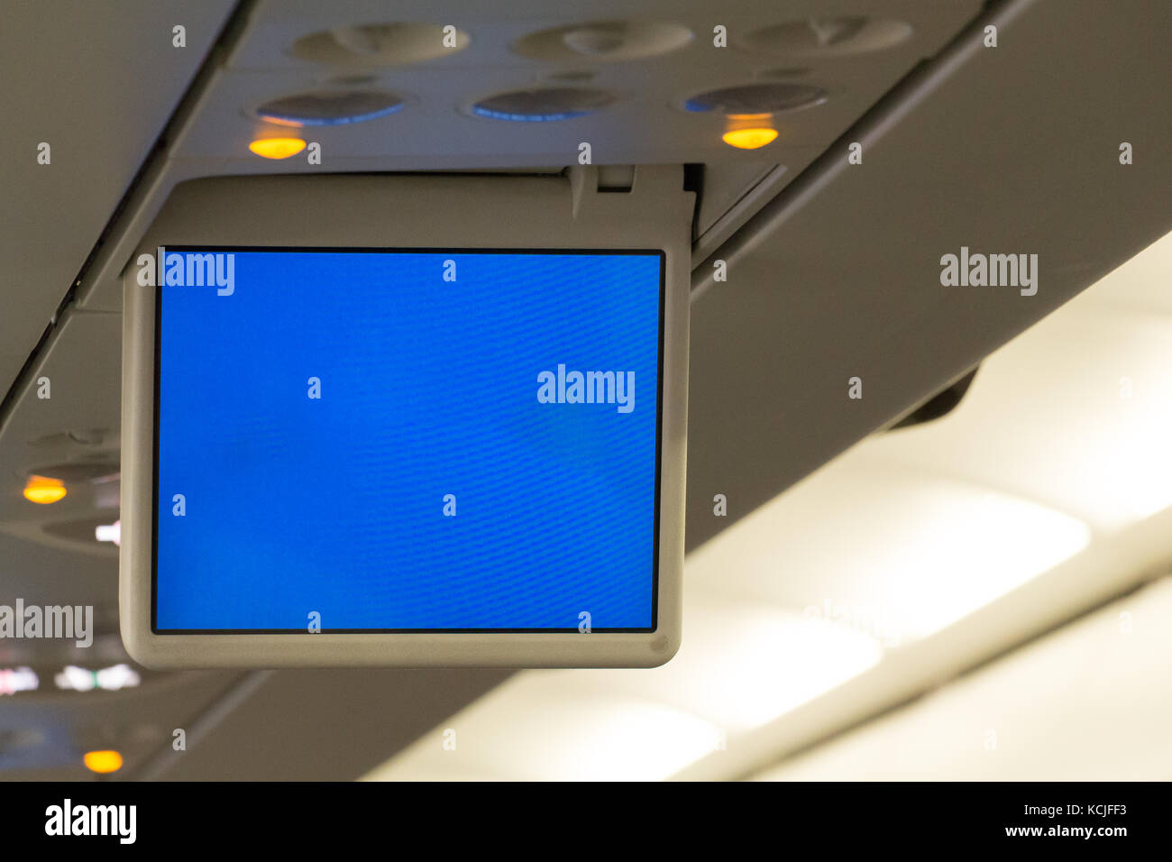 An in-flight monitor is attached on the ceiling in the economy class ...