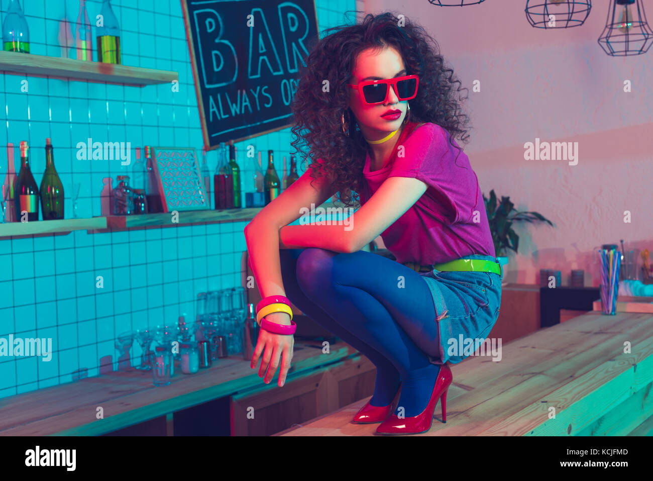 stylish woman sitting on counter Stock Photo - Alamy