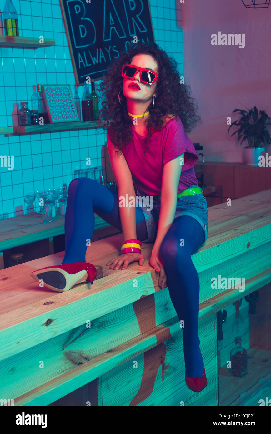 stylish woman sitting on counter Stock Photo - Alamy