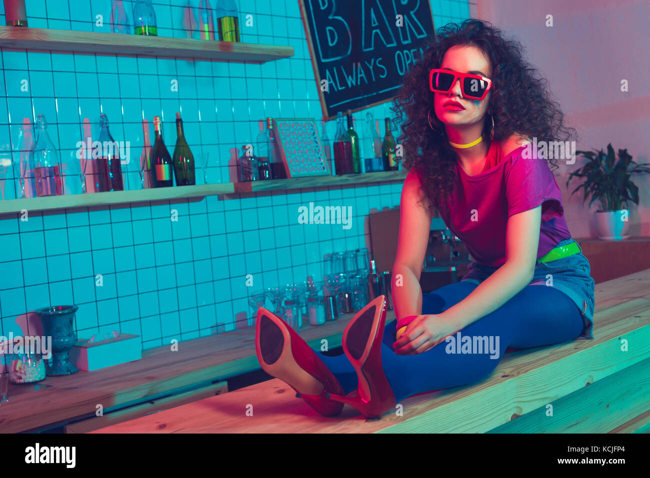 stylish woman sitting on counter Stock Photo - Alamy