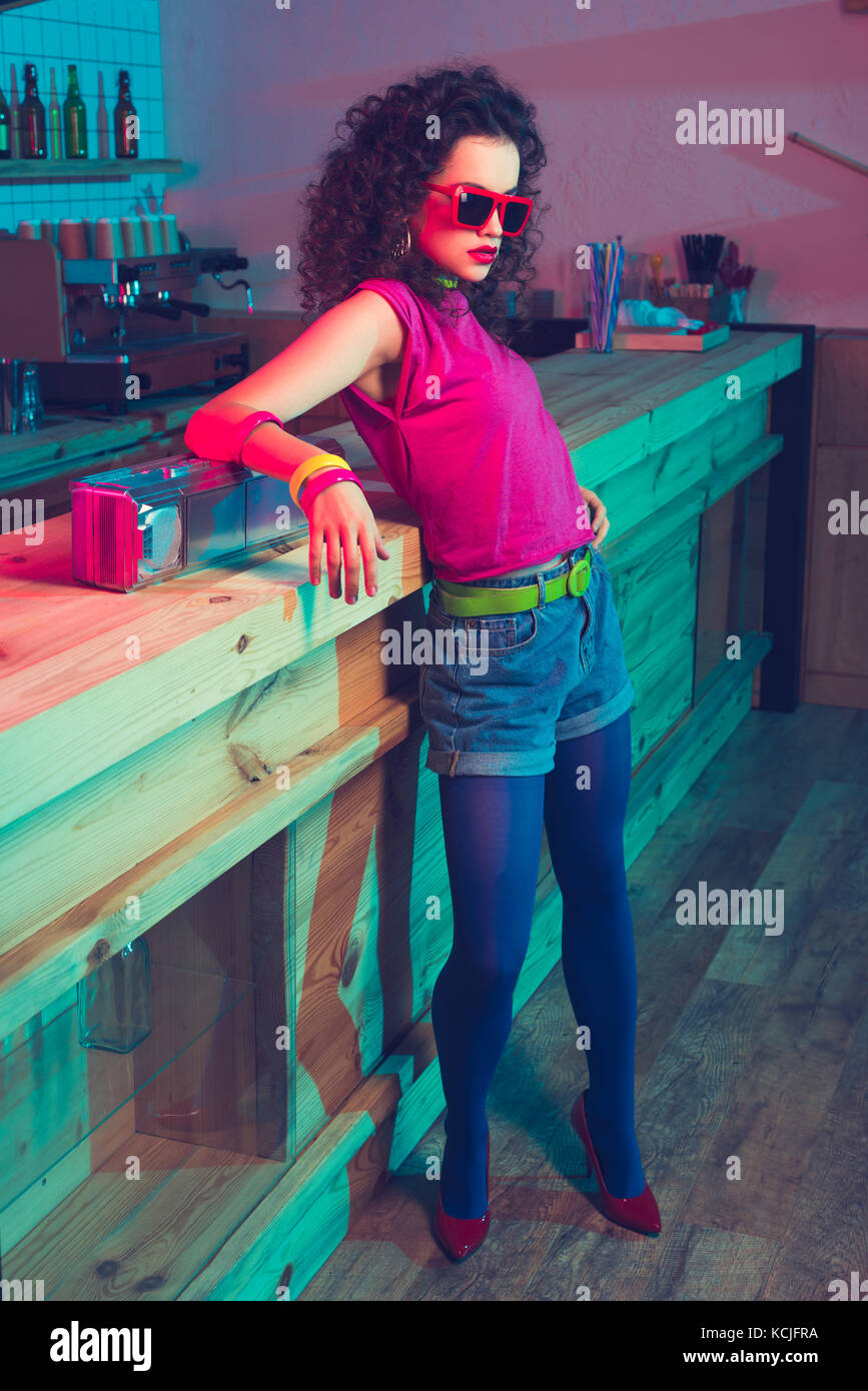 fashionable woman leaning on counter Stock Photo - Alamy