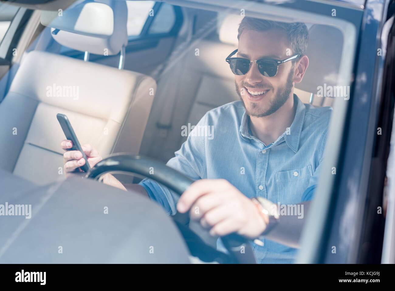 man with smartphone driving car Stock Photo - Alamy